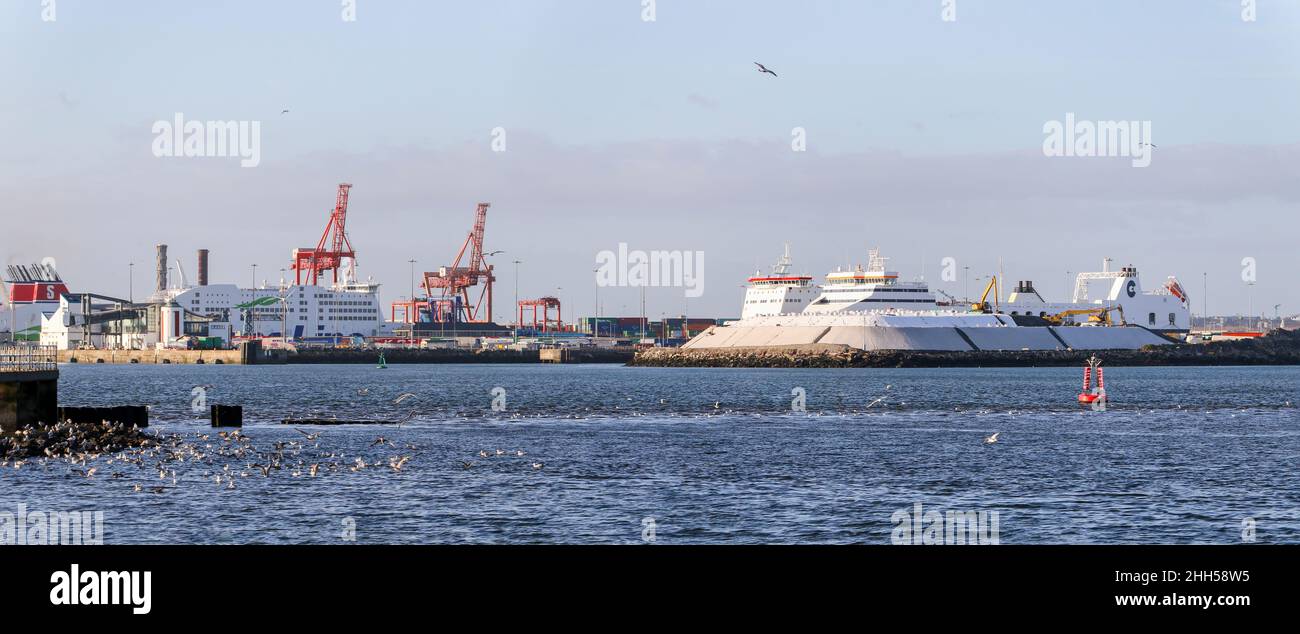 Industrial cranes, ships and freight containers in Dublin Port shipping ...