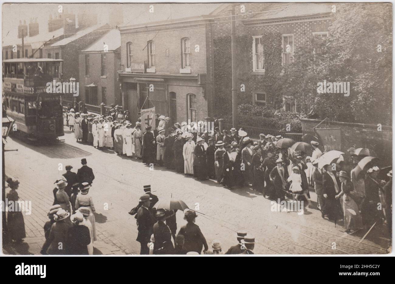 Church parade: line of women parading through a street, watched by a ...