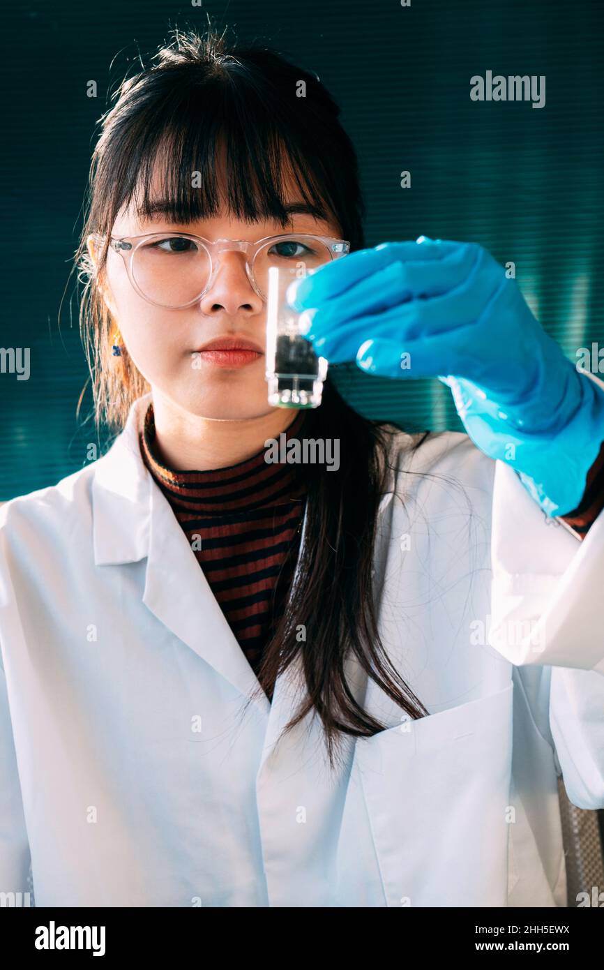 Young scientist doing experiment with liquid solution in laboratory ...