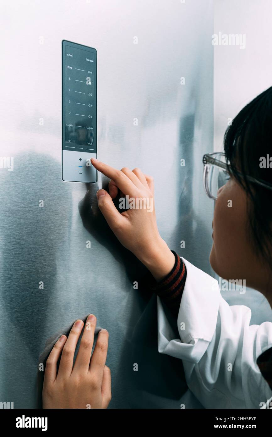 Young scientist pointing at control panel while working in laboratory ...