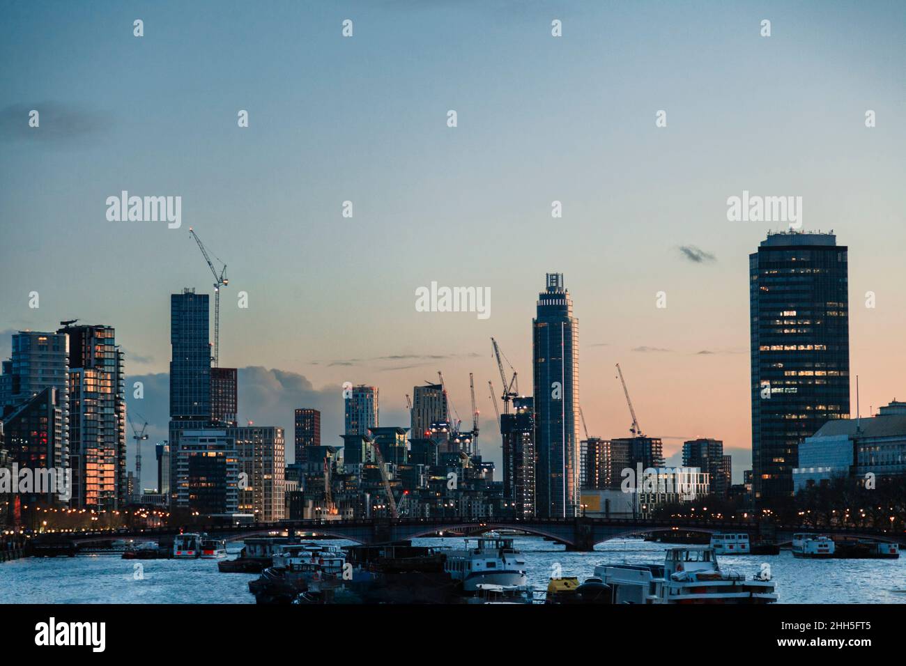 Tall modern buildings and river in capital city at sunset, London ...