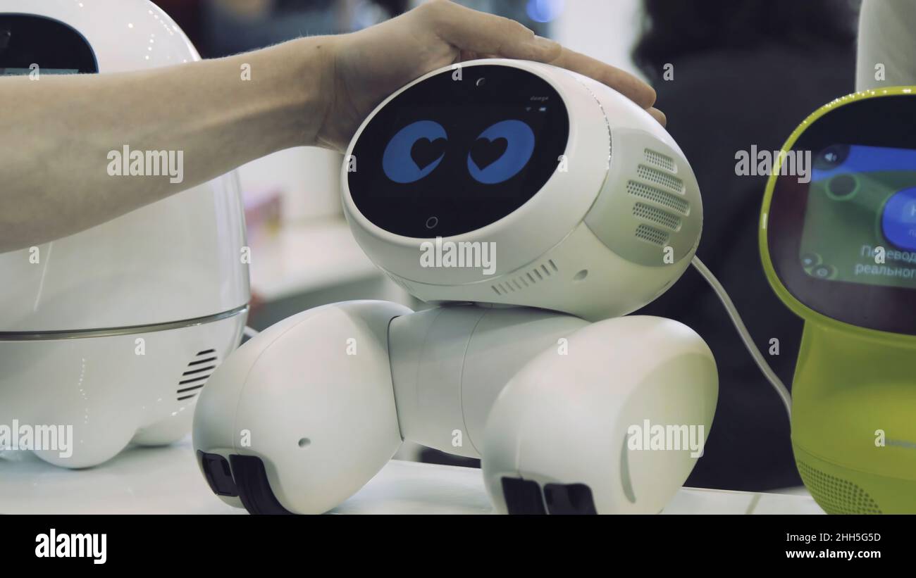 Hand of man touches the robot. Robot is happy with the touch of a human ...