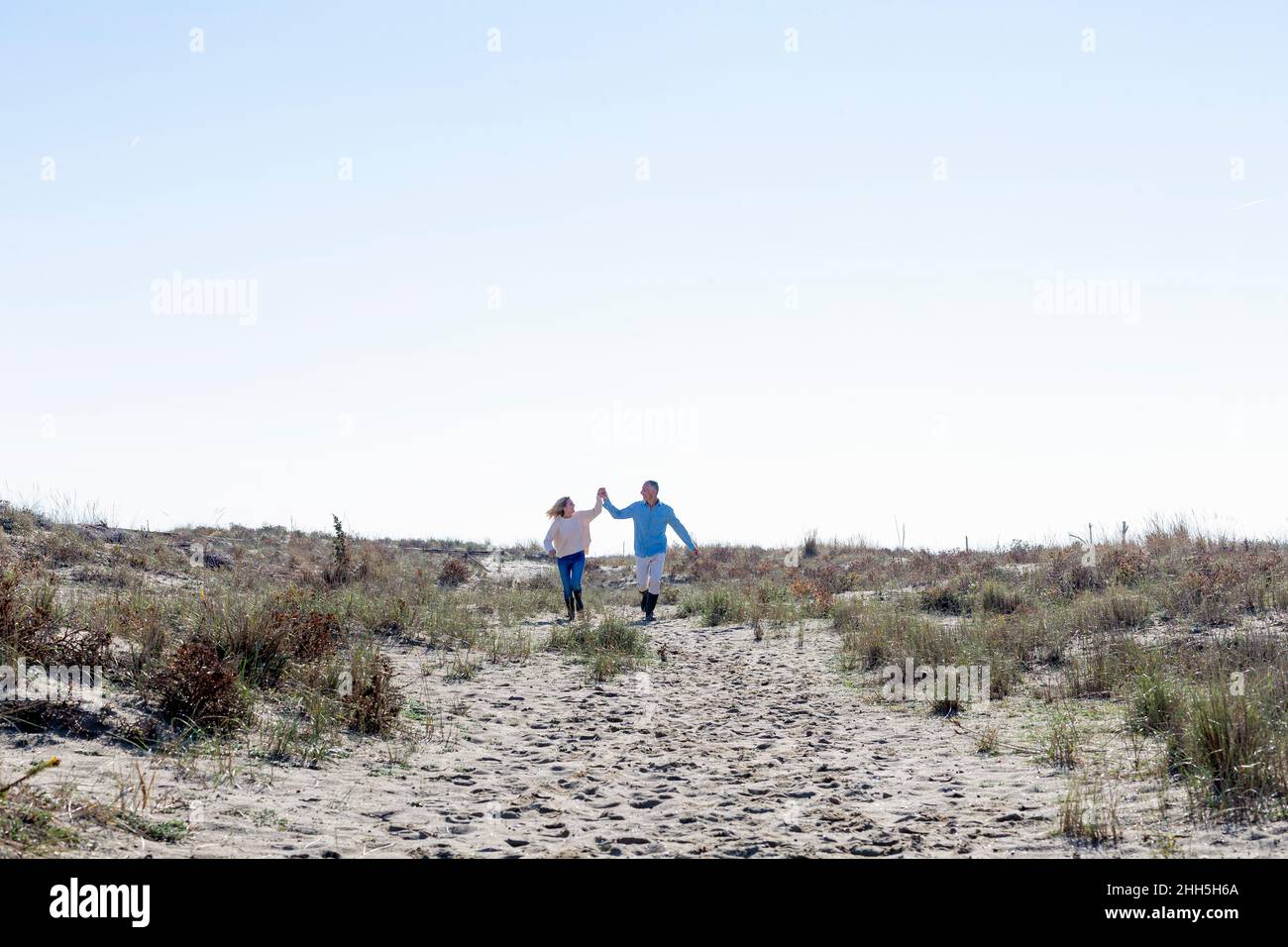 Happy couple running on sand enjoying sunny weekend together Stock ...