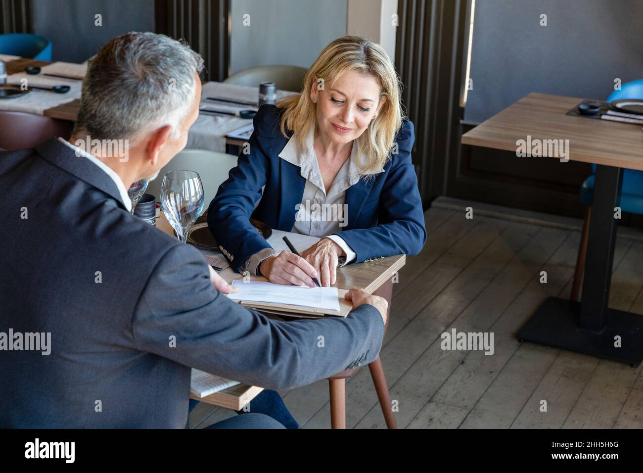 Client signing contract at meeting with businessman in restaurant Stock ...