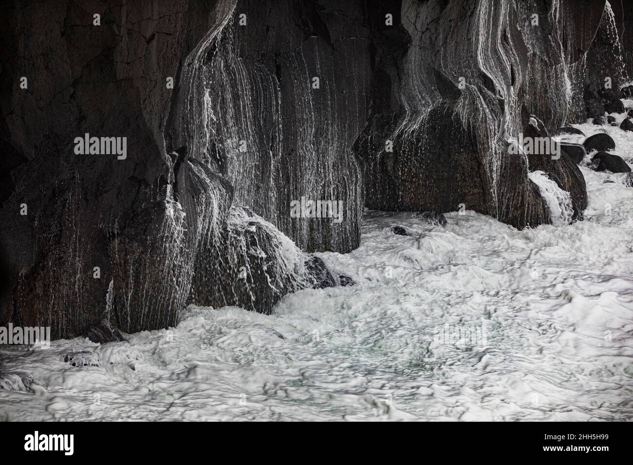 Volcanic rock cliff with splashing sea water in Ponta da Ferraria, San ...
