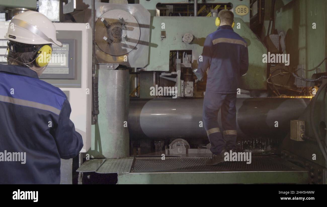 Making metal pipes and tubes in an engineering factory. Worker on the ...