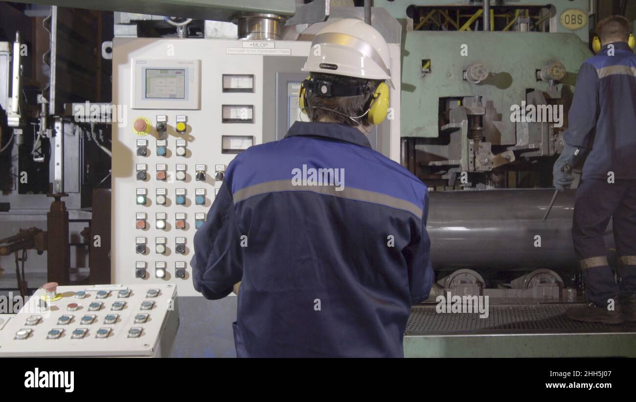 Making metal pipes and tubes in an engineering factory. Worker on the ...