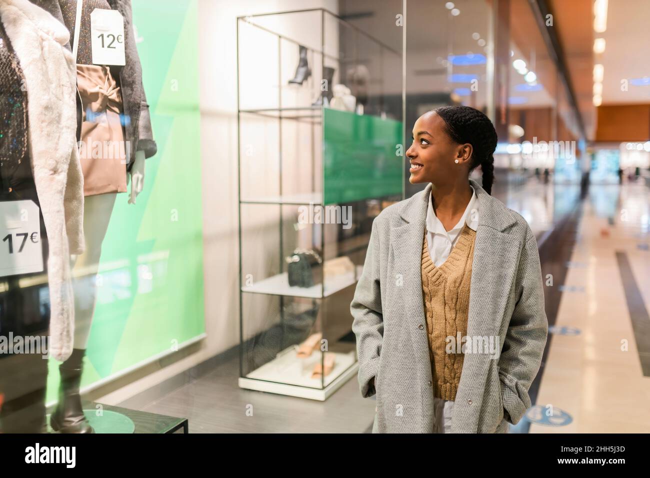 Smiling teenage girl window shopping in mall Stock Photo - Alamy