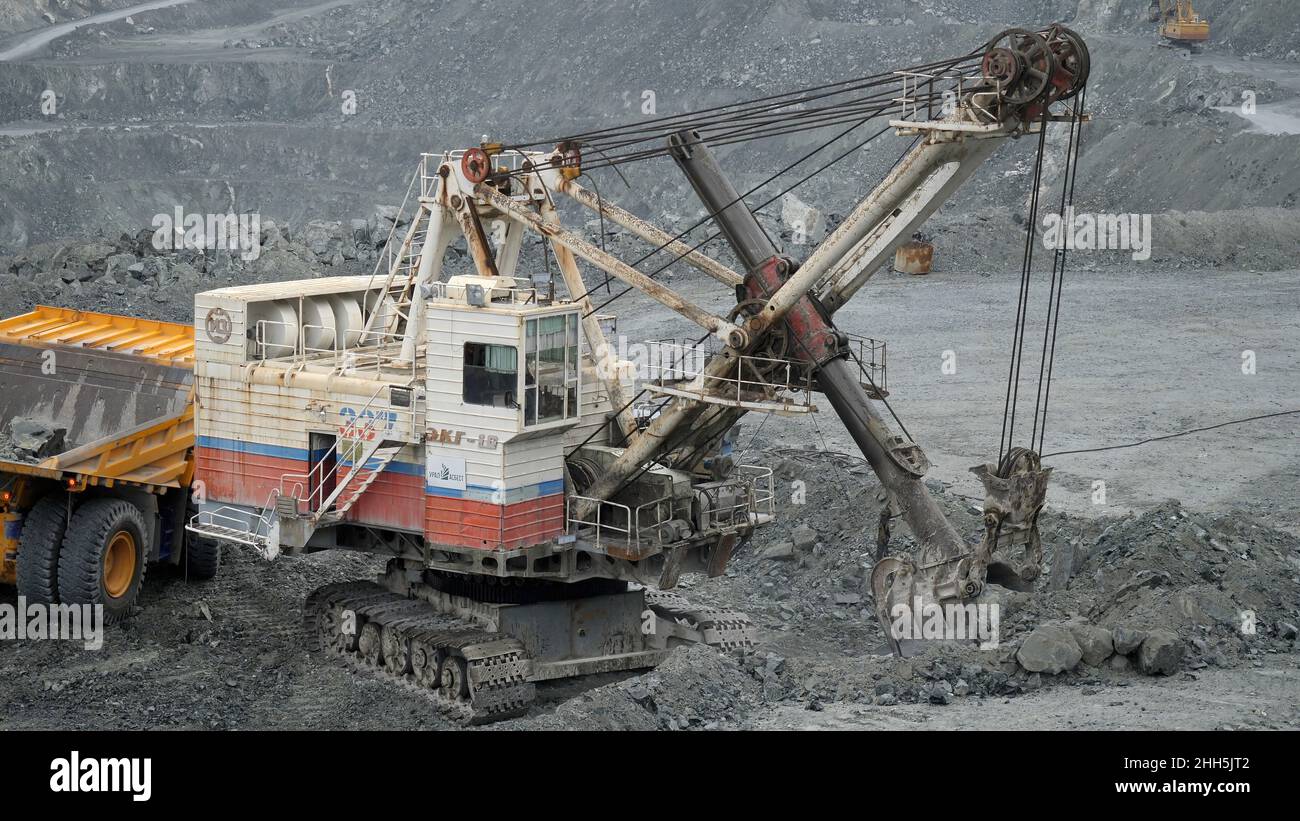 Mining excavator scooping up ore in a quarry. Close up of limestone ...