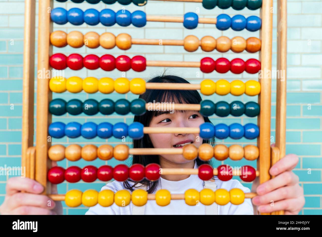 Thoughtful woman with multi colored abacus in front of brick wall Stock ...