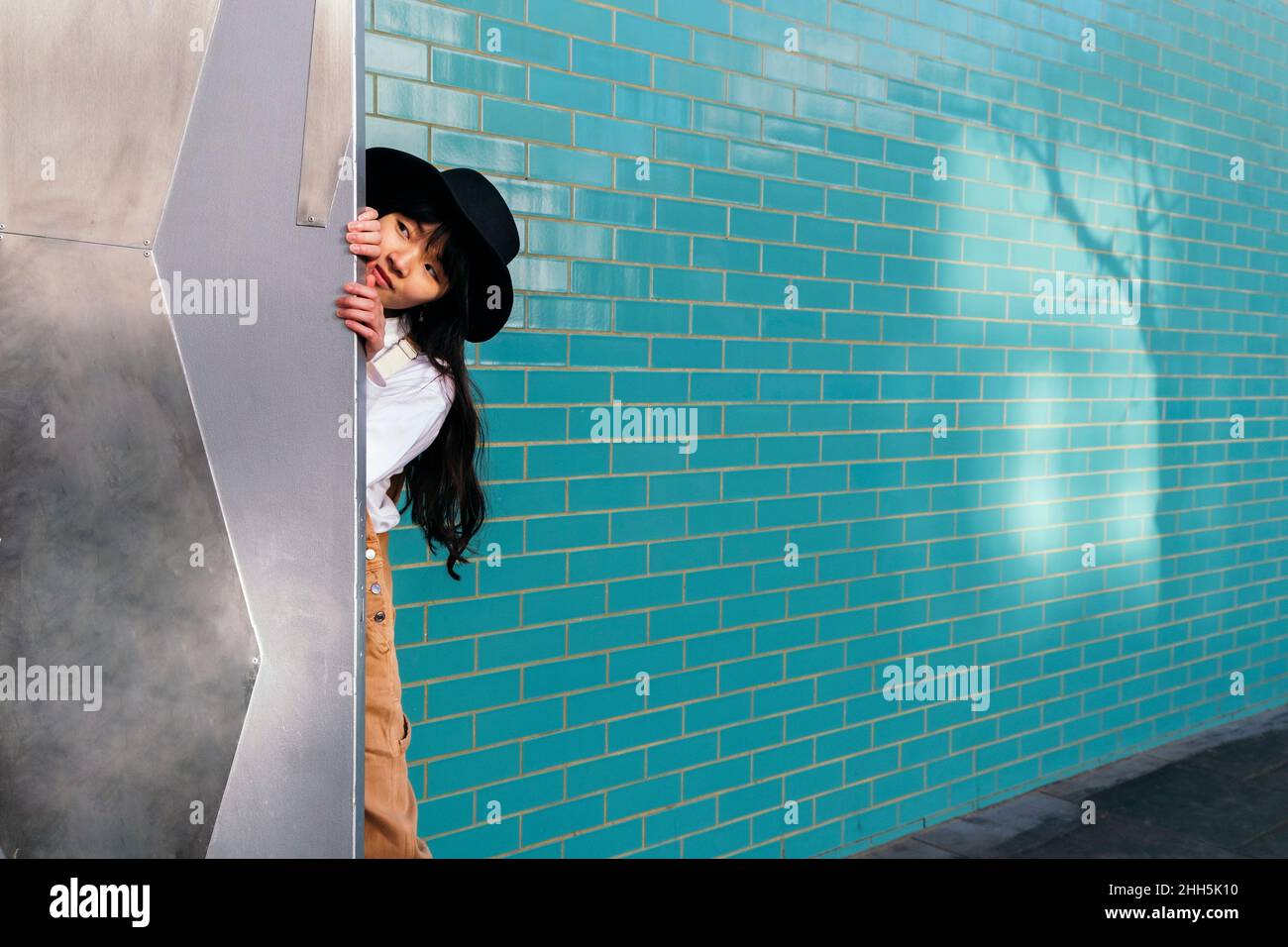 Woman hiding and peeking out through door Stock Photo - Alamy