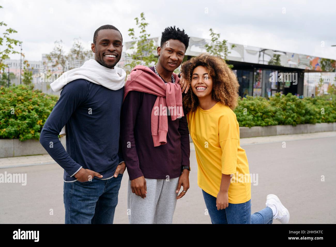 Smiling friends standing on city street Stock Photo - Alamy