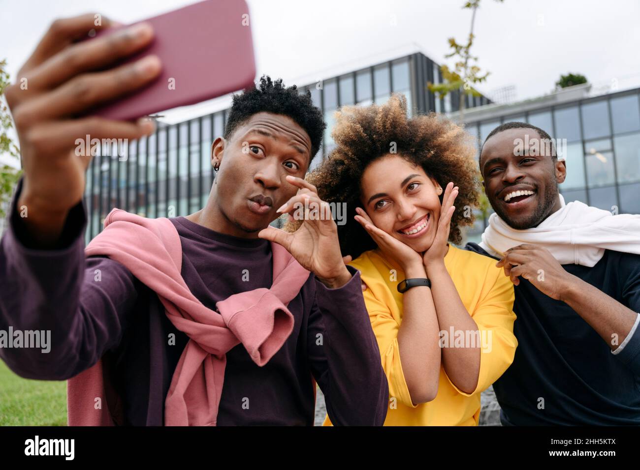Young man taking selfie with friends on mobile phone Stock Photo - Alamy