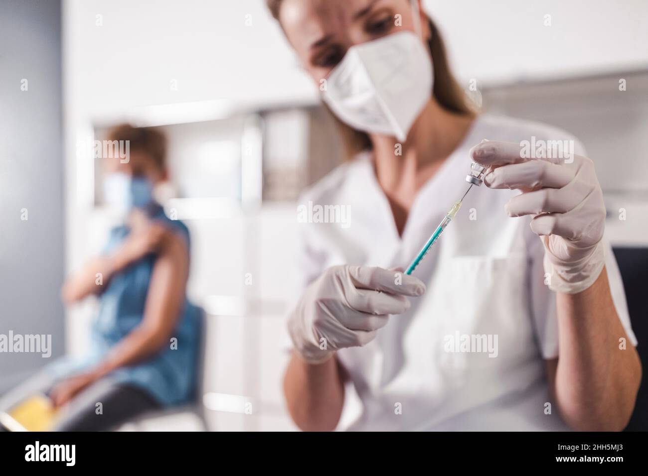 Nurse injecting syringe in vial at vaccination center Stock Photo - Alamy