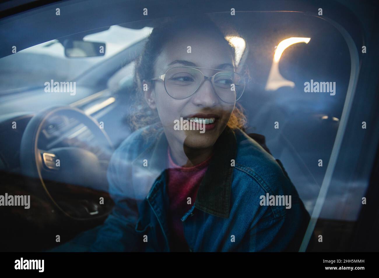 Smiling woman seen through car window Stock Photo - Alamy