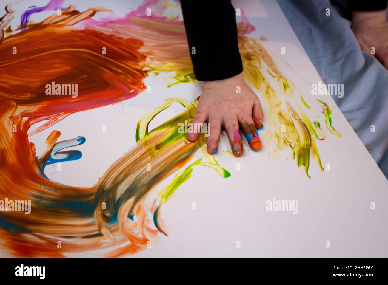 finger painting pushing paint around fun colorful Stock Photo - Alamy