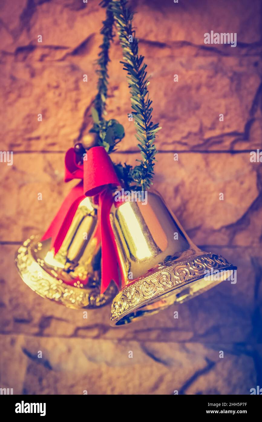 Christmas golden bells with a red bow hanging on the brick wall ...