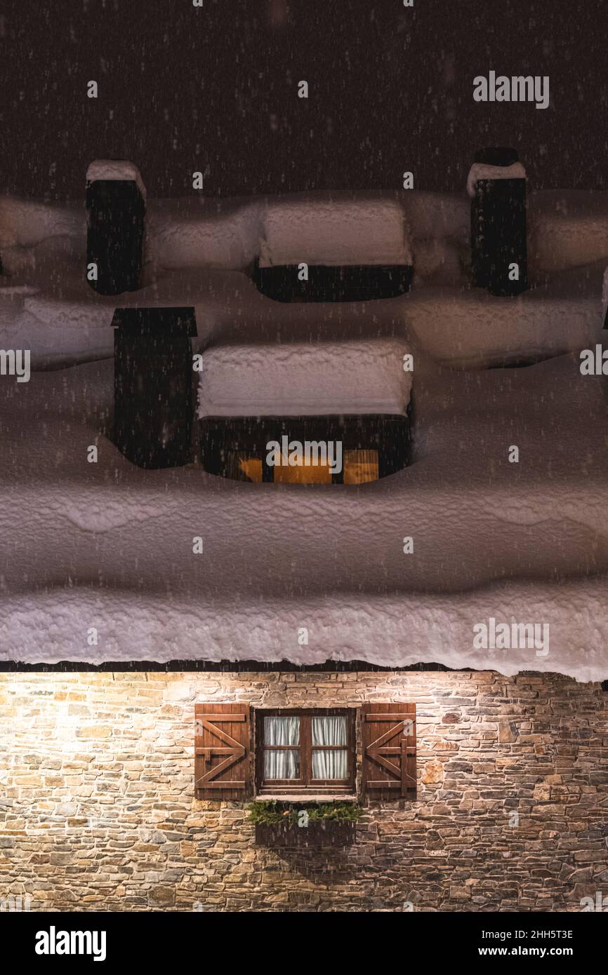 Snow falling outside brick house at night Stock Photo - Alamy