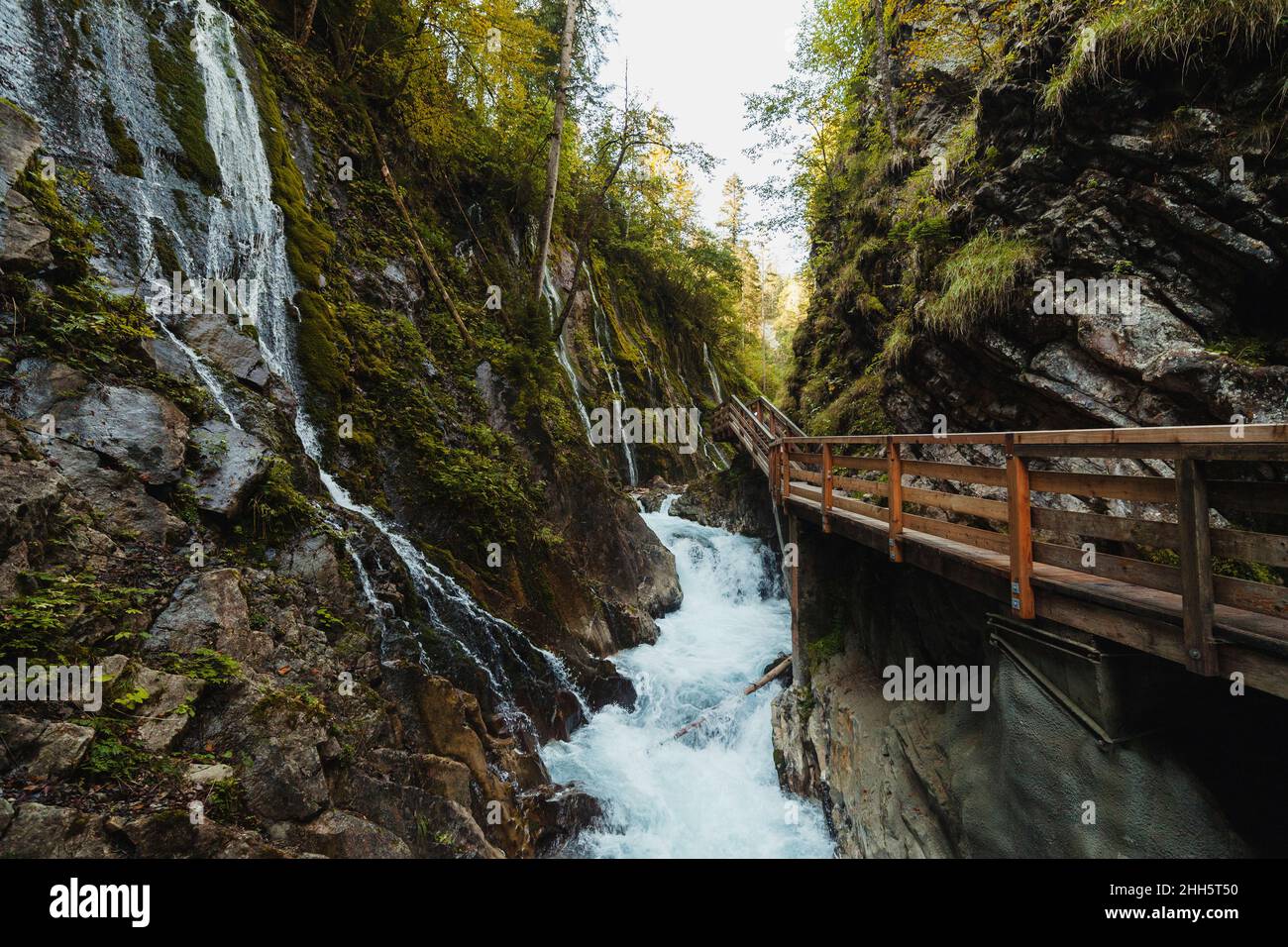 Elevated walkway stretching over river flowing through narrow ravine ...
