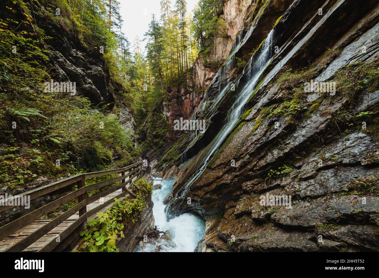 Elevated walkway stretching over river flowing through narrow ravine ...