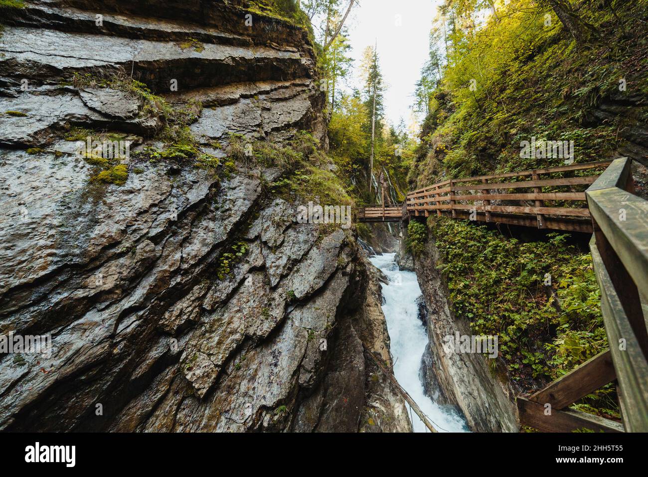 Elevated walkway stretching over river flowing through narrow ravine ...