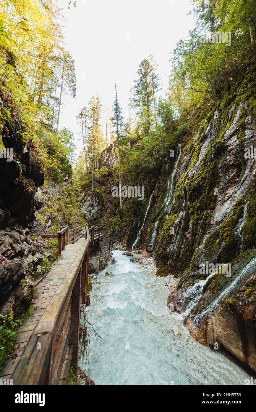 Elevated walkway stretching over river flowing through narrow ravine ...