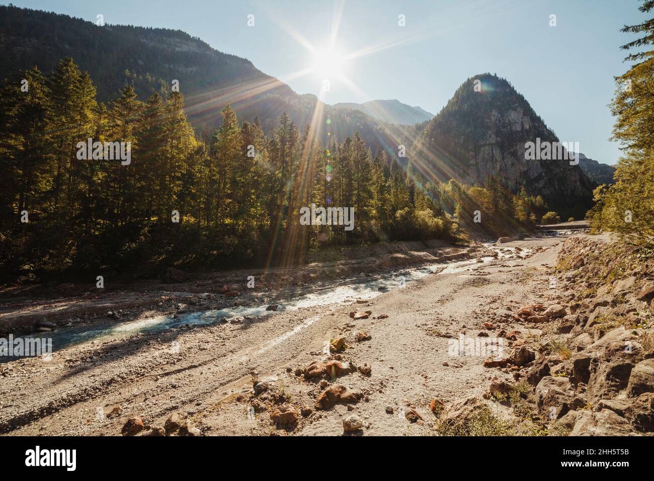 Sun shining over alpine stream Stock Photo - Alamy