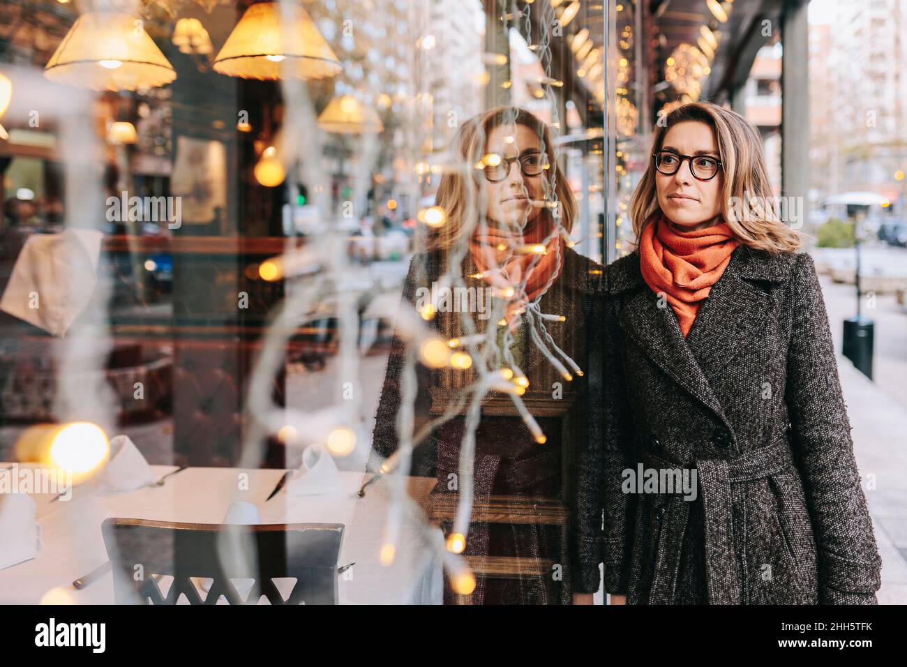Woman doing window shopping leaning on store window Stock Photo - Alamy