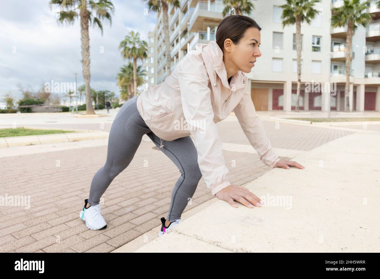 Dedicated woman exercising on concrete Stock Photo - Alamy