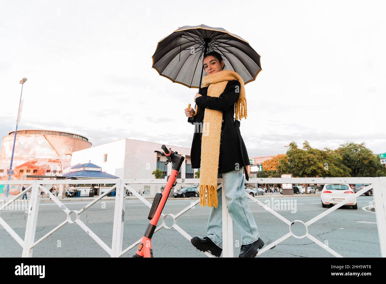 Teenage girl with umbrella standing on railing Stock Photo - Alamy