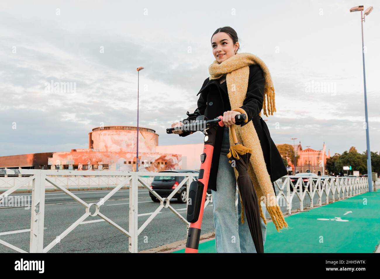 Teenager riding electric push scooter in front of sky Stock Photo - Alamy