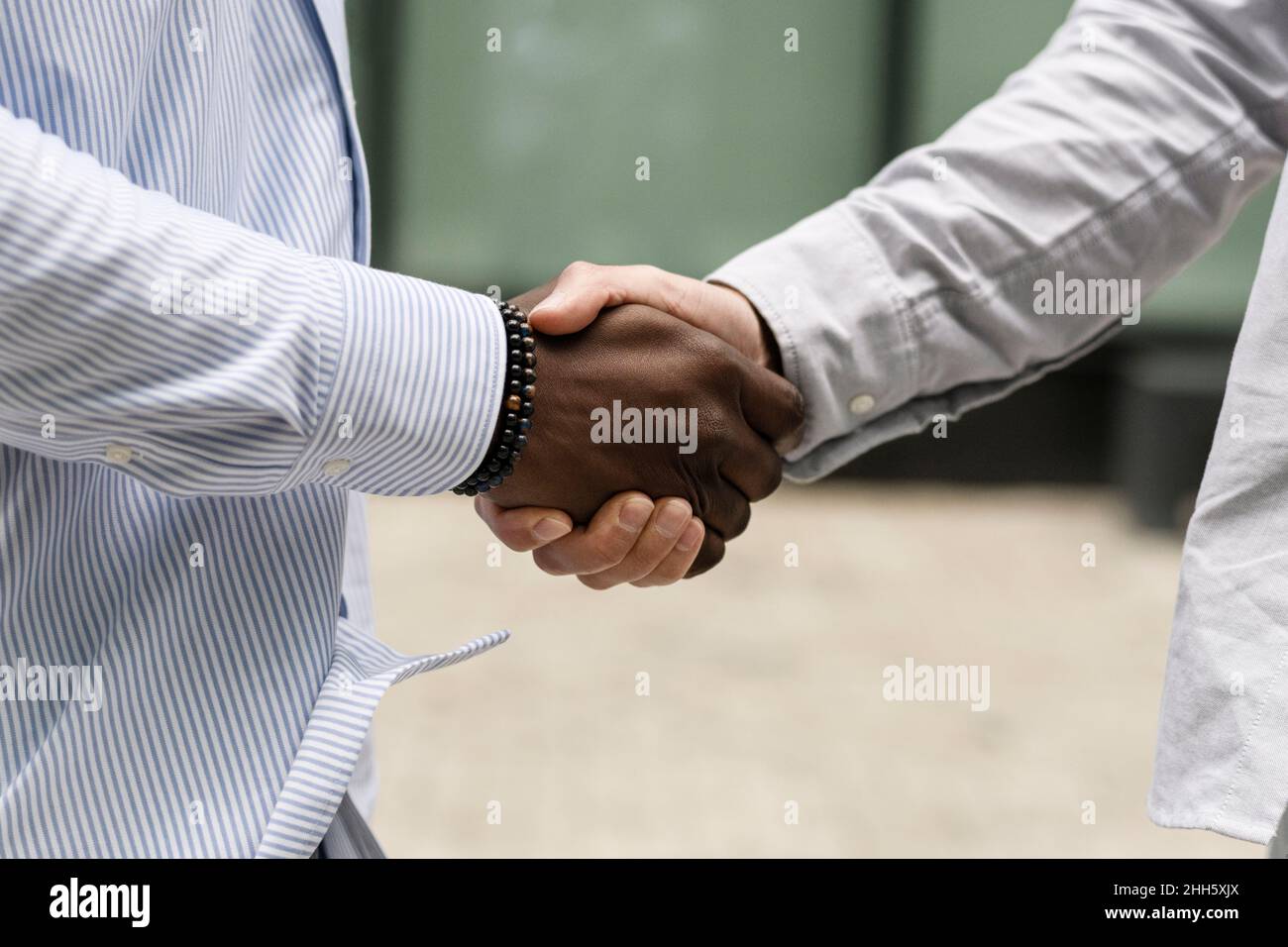 Multiracial friends doing handshake Stock Photo - Alamy
