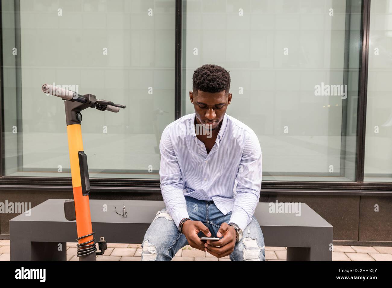 Man texting through mobile phone in front of wall Stock Photo - Alamy