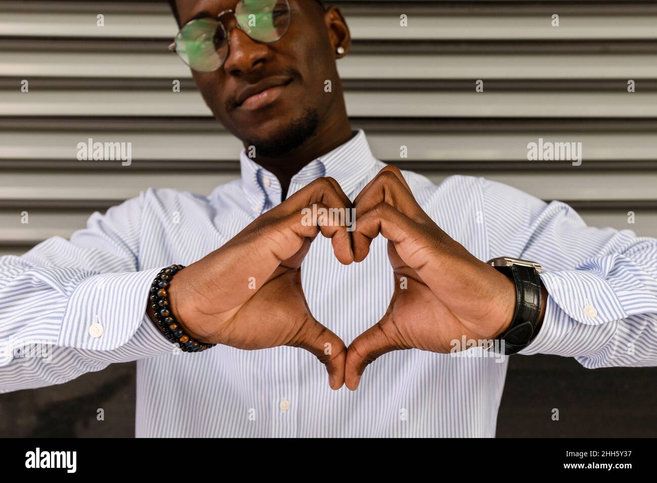 Young man making heart shape with hands Stock Photo - Alamy