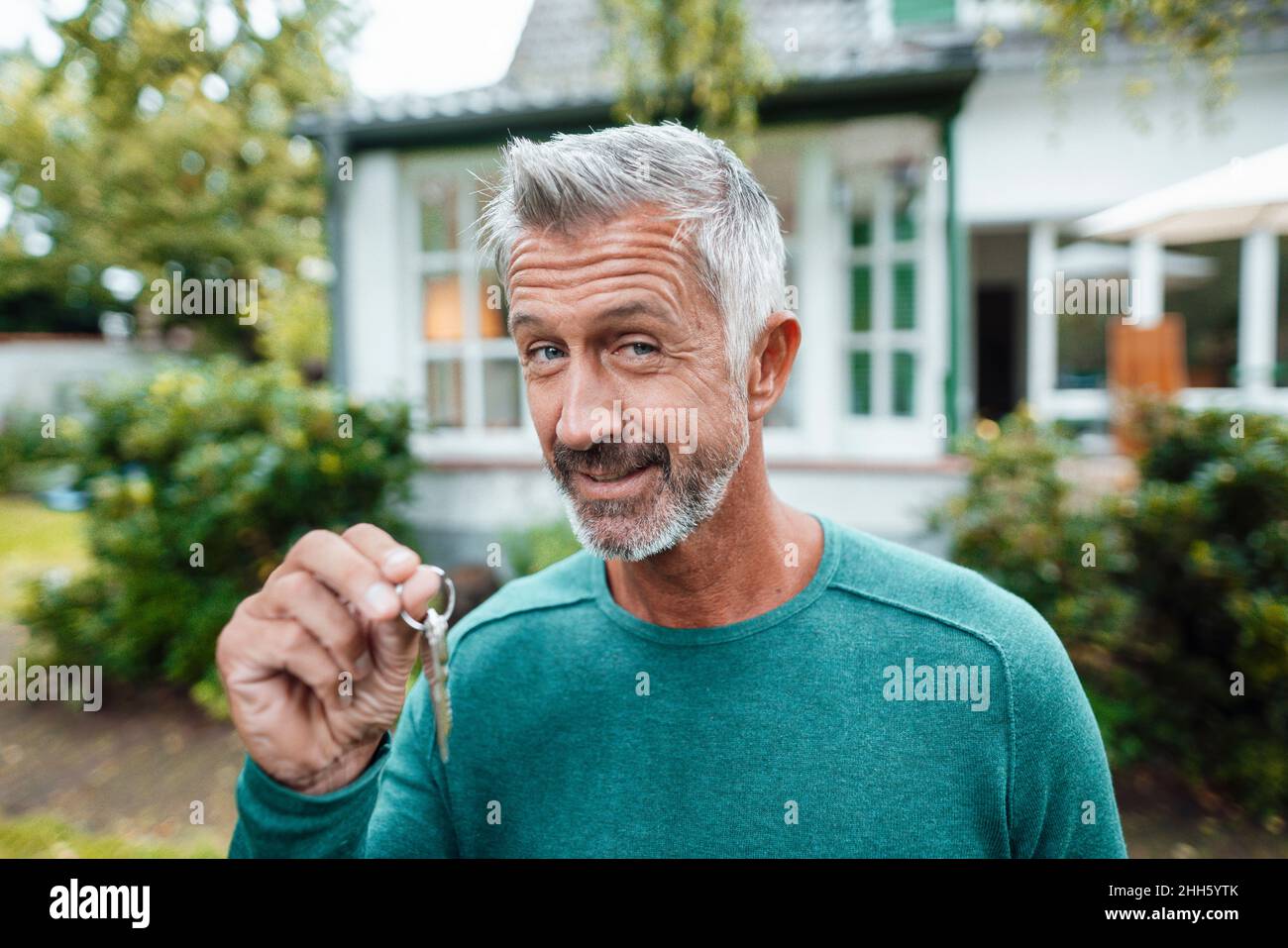 Man showing keys in backyard Stock Photo - Alamy