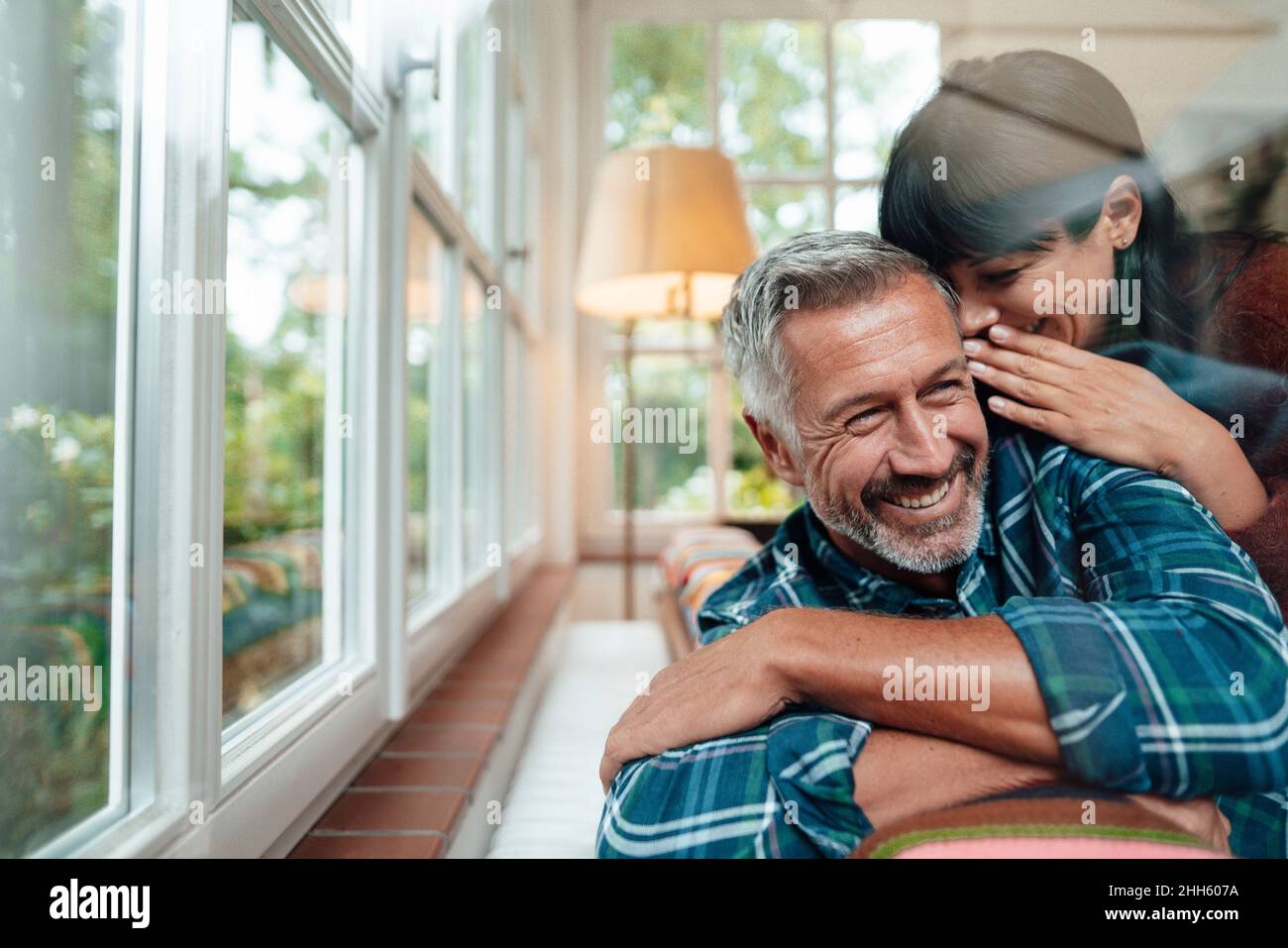 Woman whispering in mans ear hi-res stock photography and images - Alamy