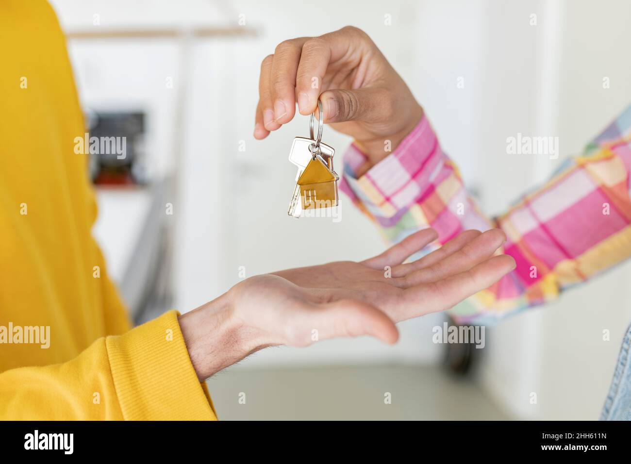 Woman giving house key to man Stock Photo - Alamy