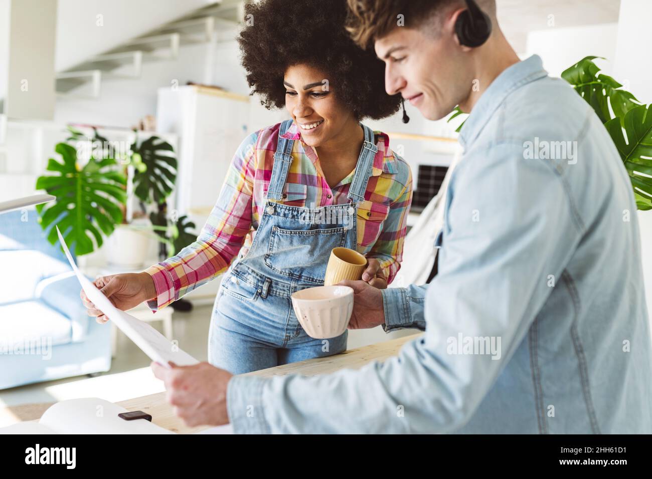 Young businessman sharing work document with woman at home Stock Photo ...