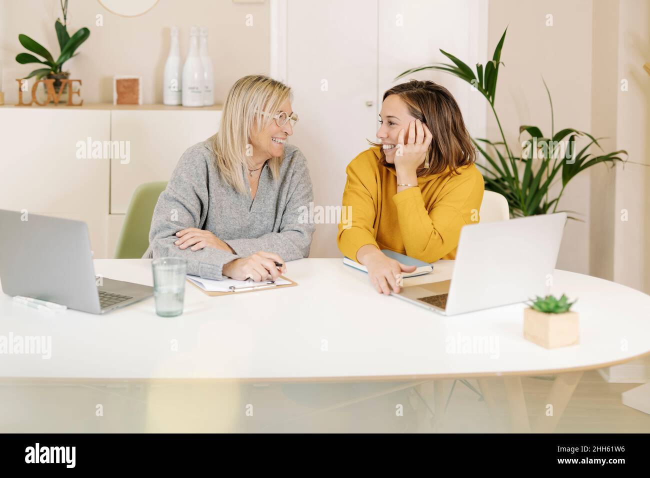 Smiling colleagues looking at each other in office Stock Photo - Alamy