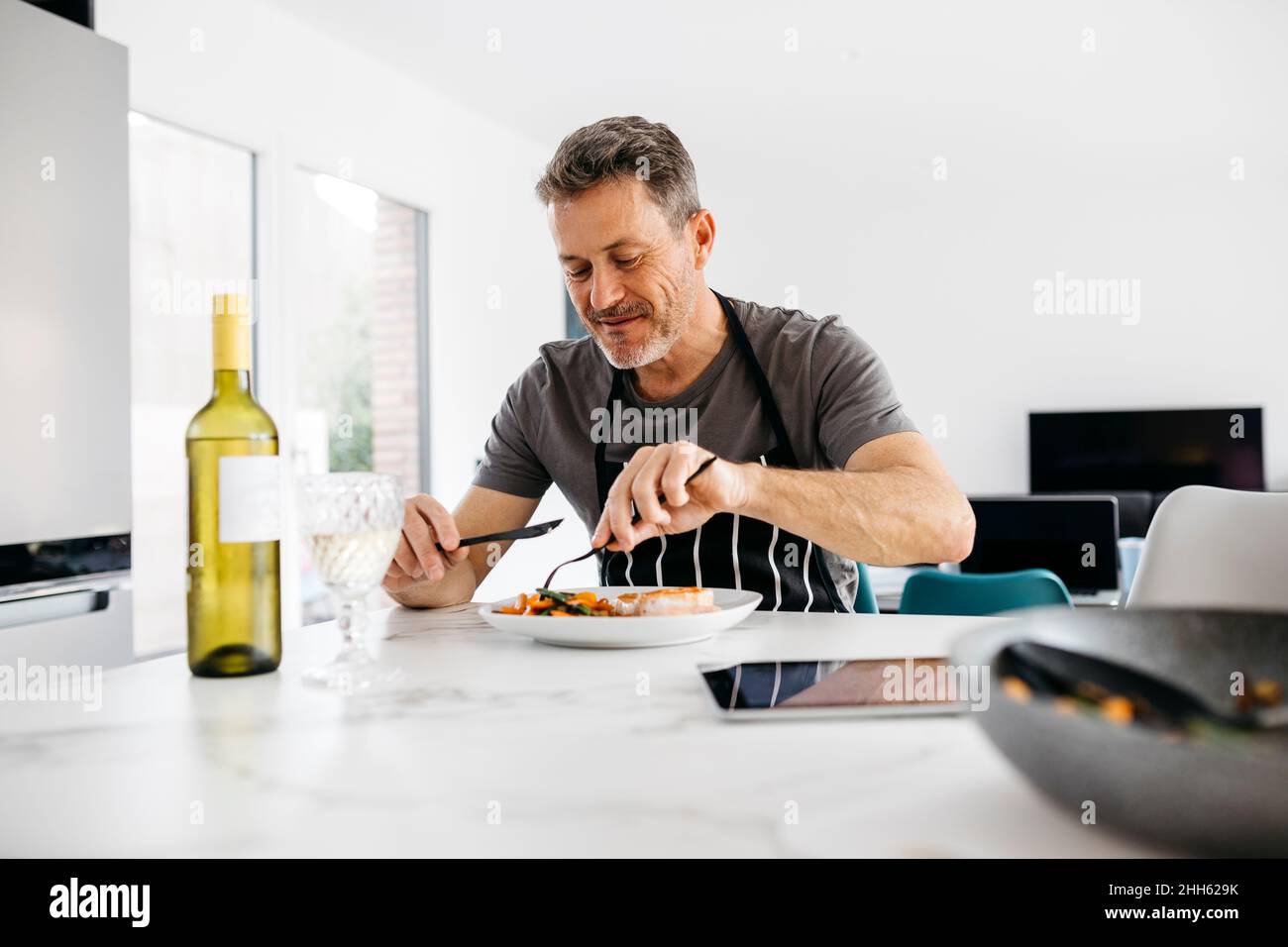 Hungry man eating food at home Stock Photo - Alamy