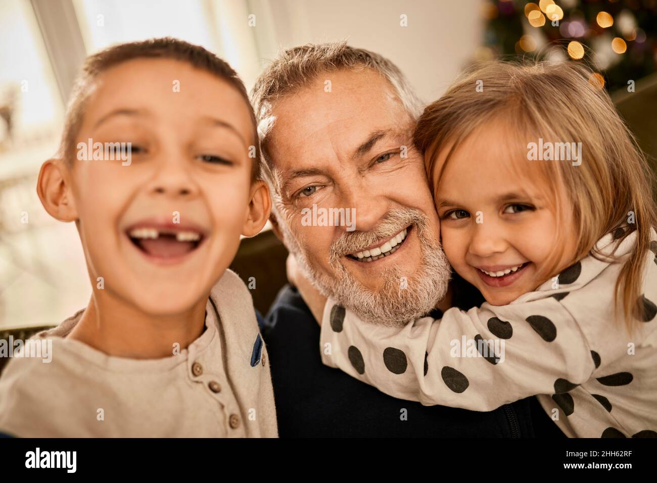 Happy grandchildren with grandfather at home Stock Photo - Alamy