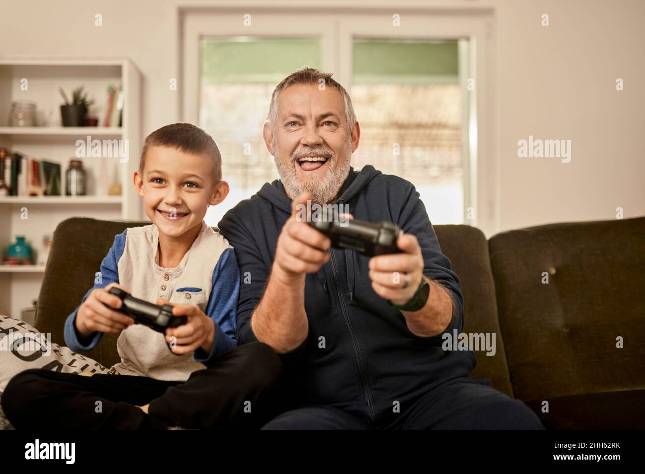 Playful grandfather playing video game with grandson at home Stock ...