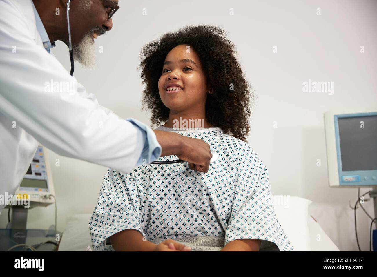 Smiling patient talking to doctor examining at hospital Stock Photo - Alamy