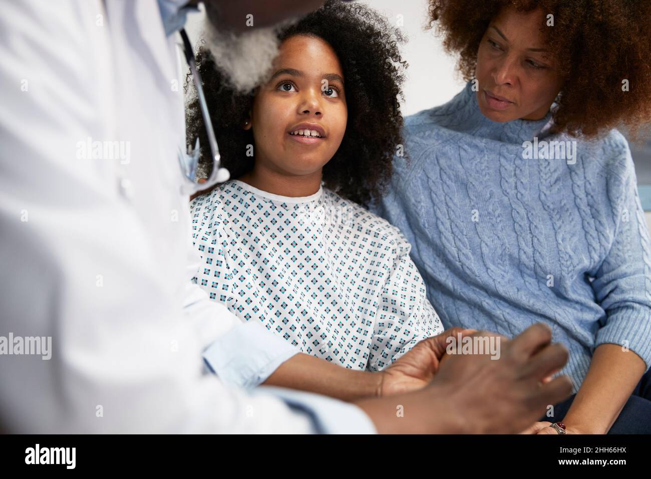 Patient with mother talking to doctor at hospital Stock Photo - Alamy