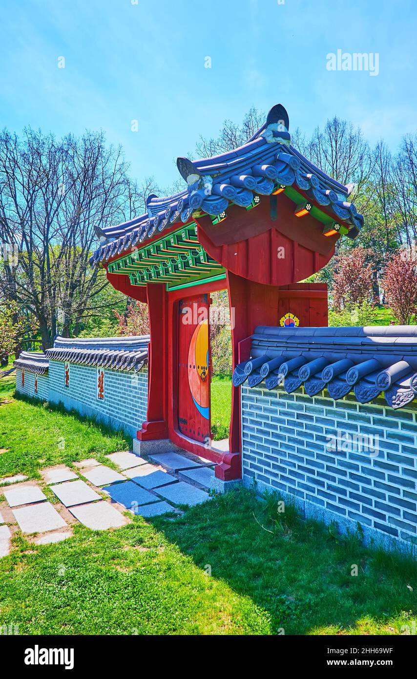 The tile roof, carved wooden gate with colorful patterns and the brick ...