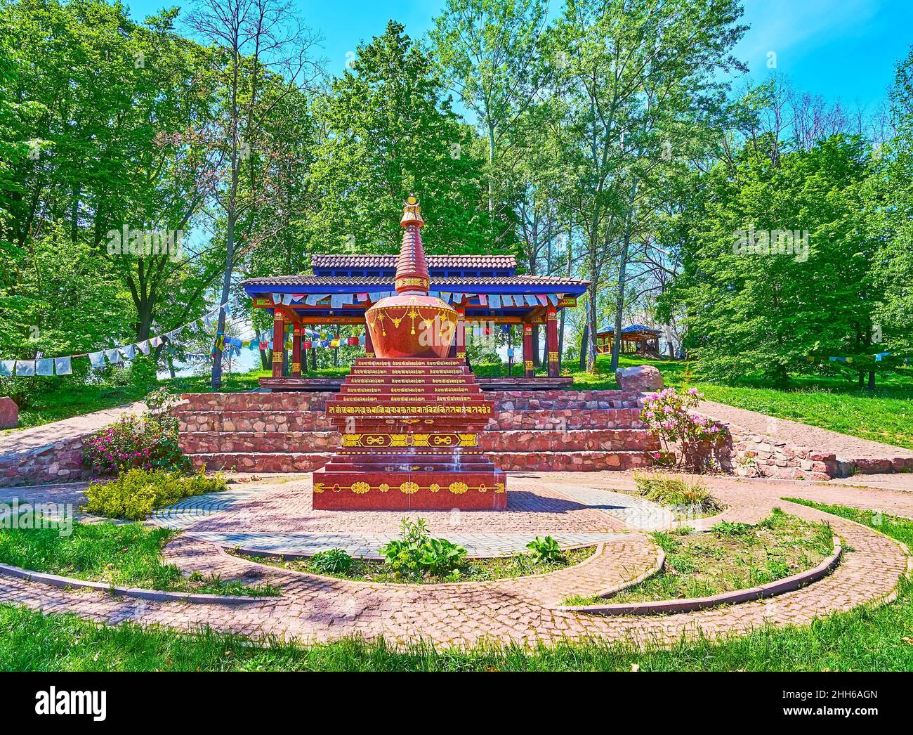The lush greenery surrounds traditional Tibetan Garden with red stone ...