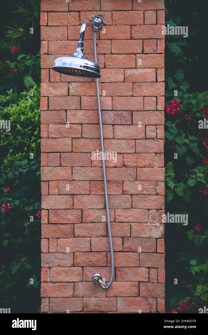 Outside large chrome shower on brick wall at swimming pool area Stock ...