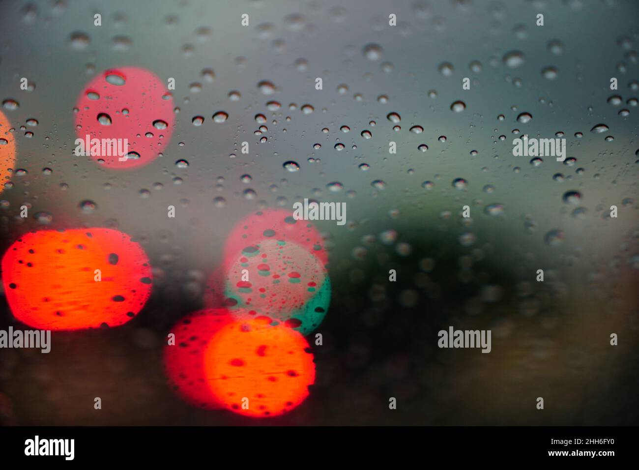 Traffic light bokeh with rain drops. Reflections of raindrops on glass ...