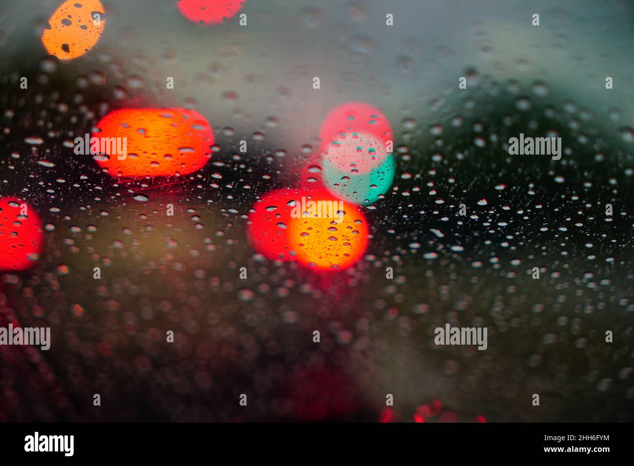 Traffic light bokeh with rain drops. Reflections of raindrops on glass ...
