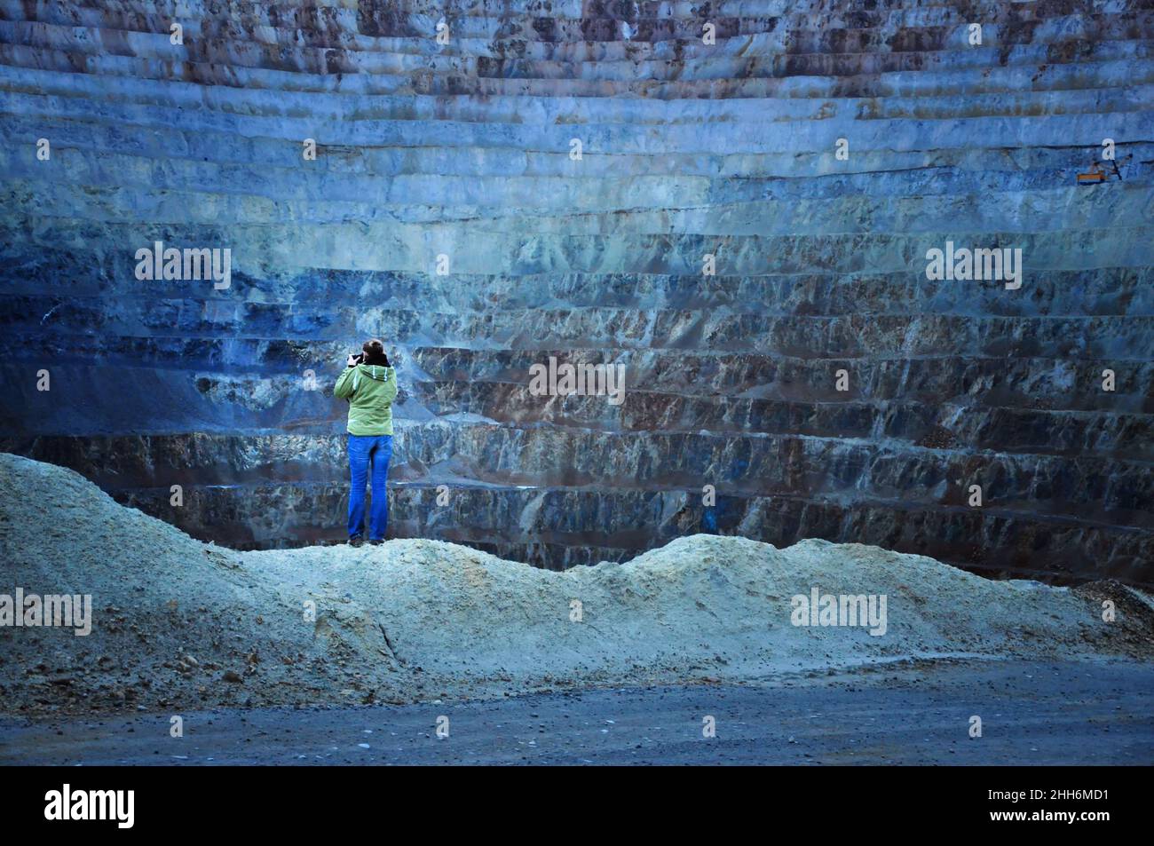 Geologist studying gigantic open cast gold and copper mine terraces ...